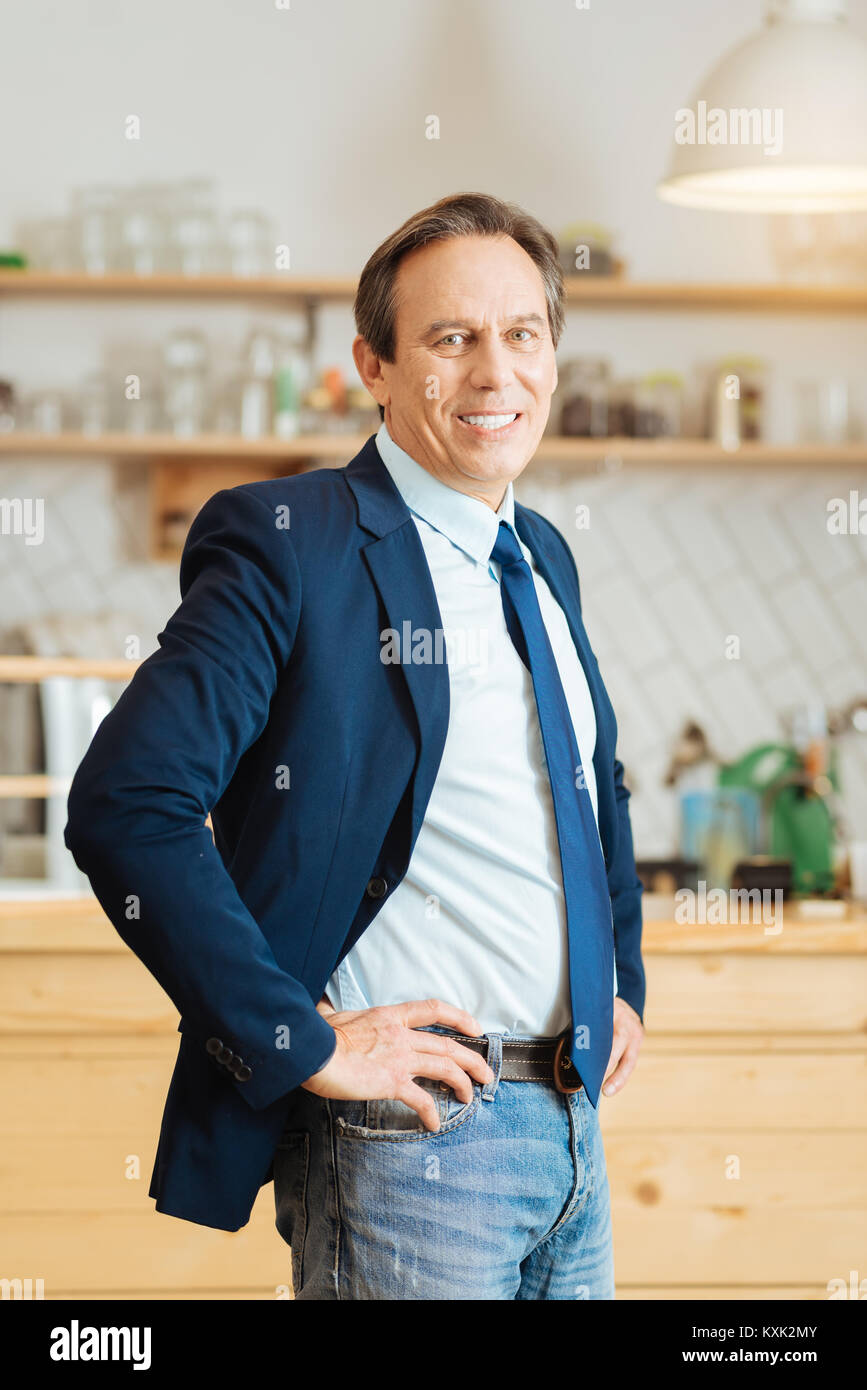 Smart clever man standing sideways and smiling Stock Photo - Alamy