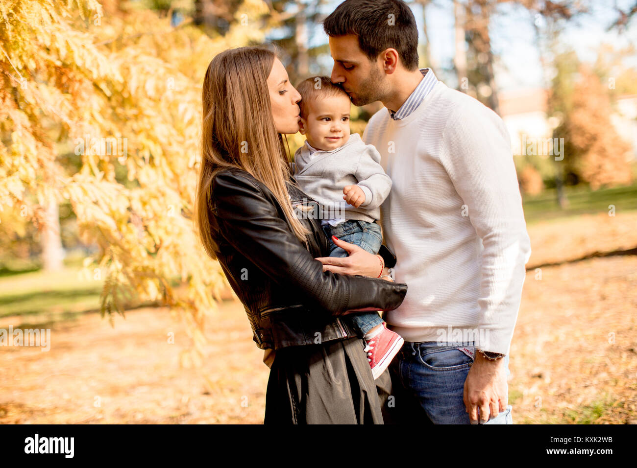 Happy young parents have fun with baby boy in autumn park Stock Photo ...