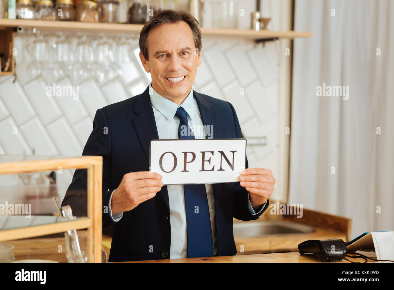 Confident reliable man looking straight and demonstrating the plate ...