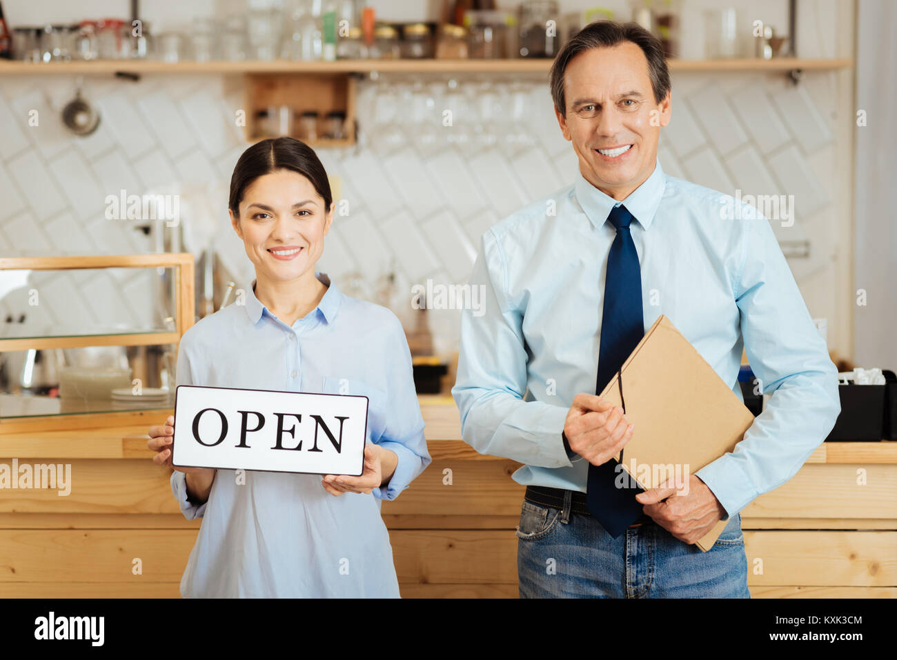 Pretty young woman smiling and showing the plate Stock Photo - Alamy