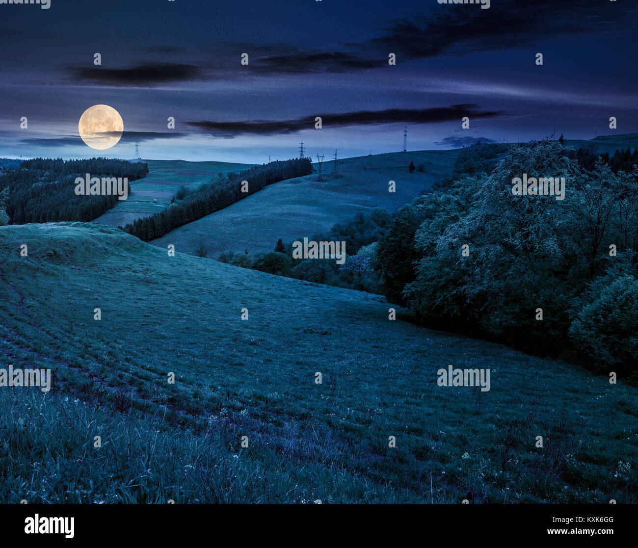 lovely countryside with grassy hills at night in full moon light ...