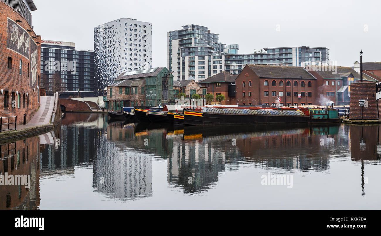 Modern buildings and canal boats reflect in the water of the Birmingham ...