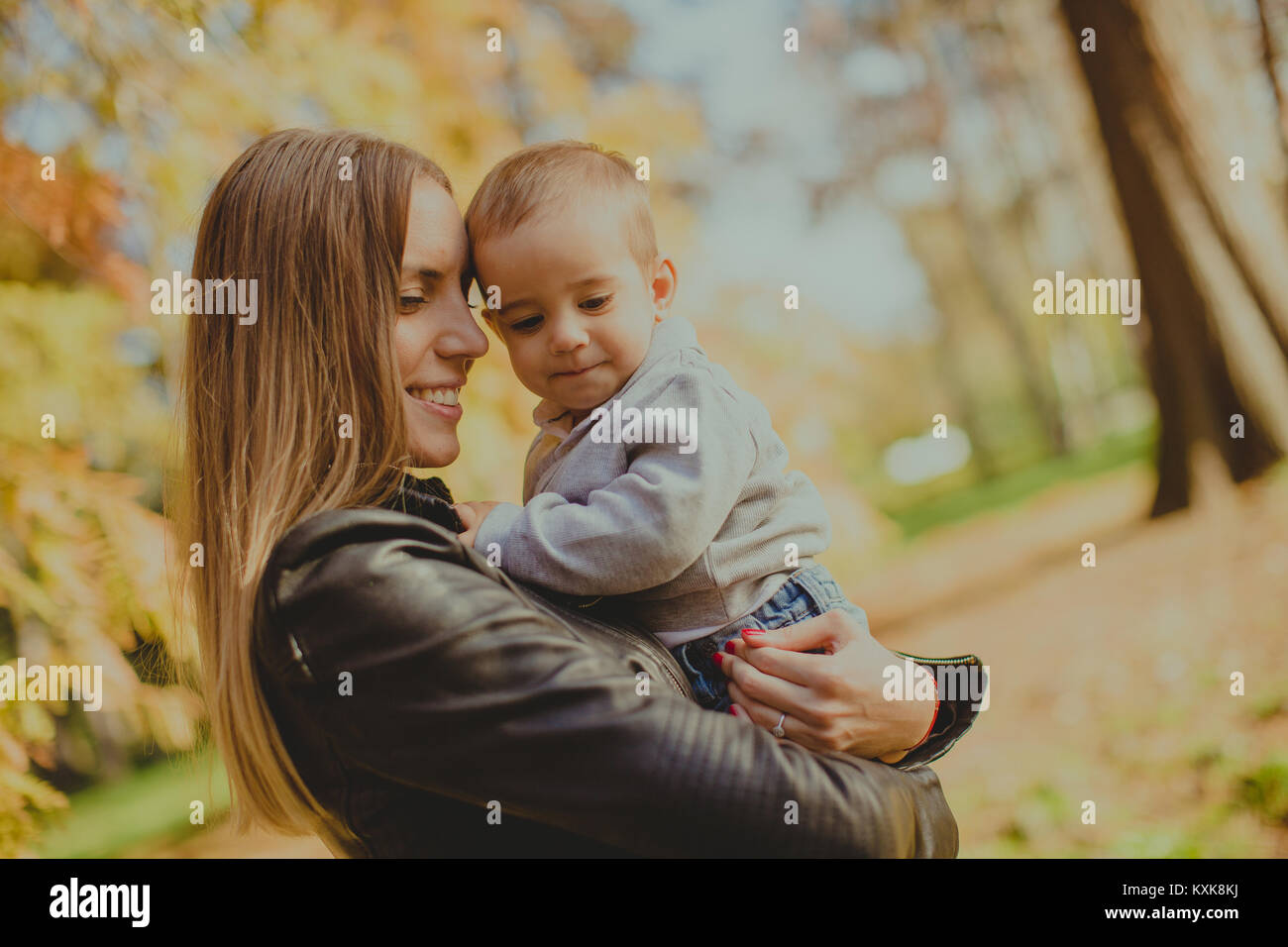 Happy young parents have fun with baby boy in autumn park Stock Photo ...