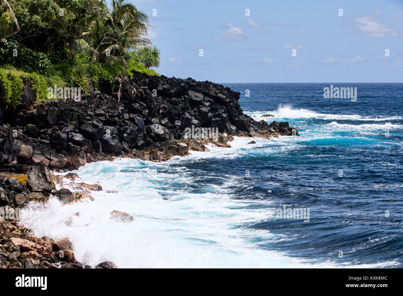 Volcanic rocks and black sand beach along shore of Maui, Hawaii with ...