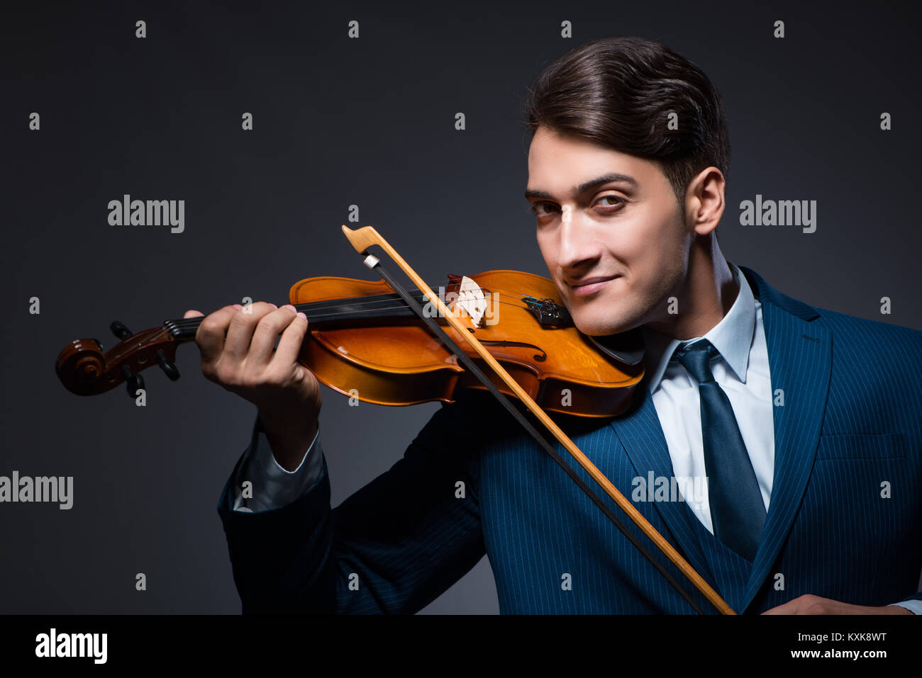 Young man playing violin in dark room Stock Photo - Alamy