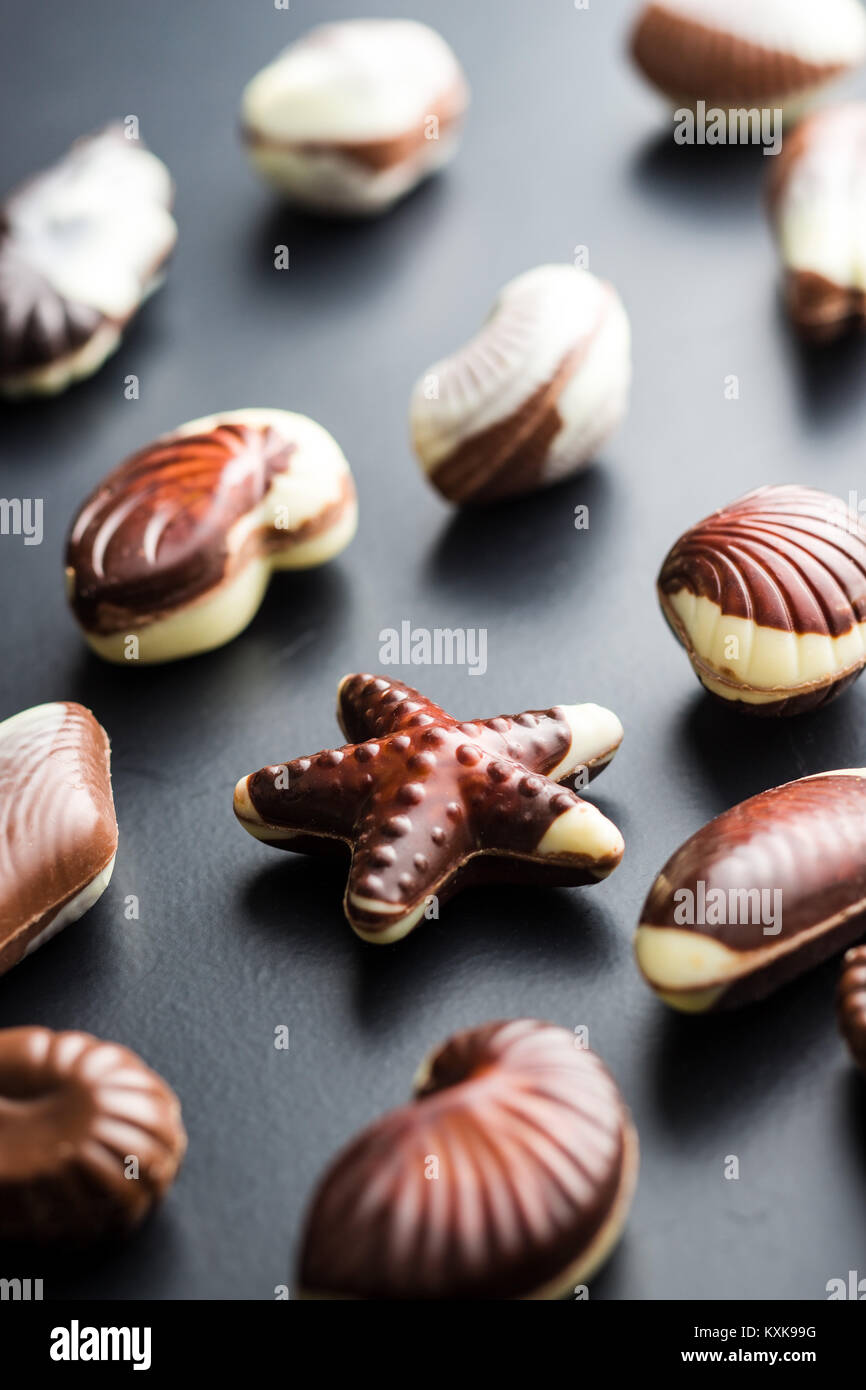 Sweet chocolate seashells on black background Stock Photo - Alamy