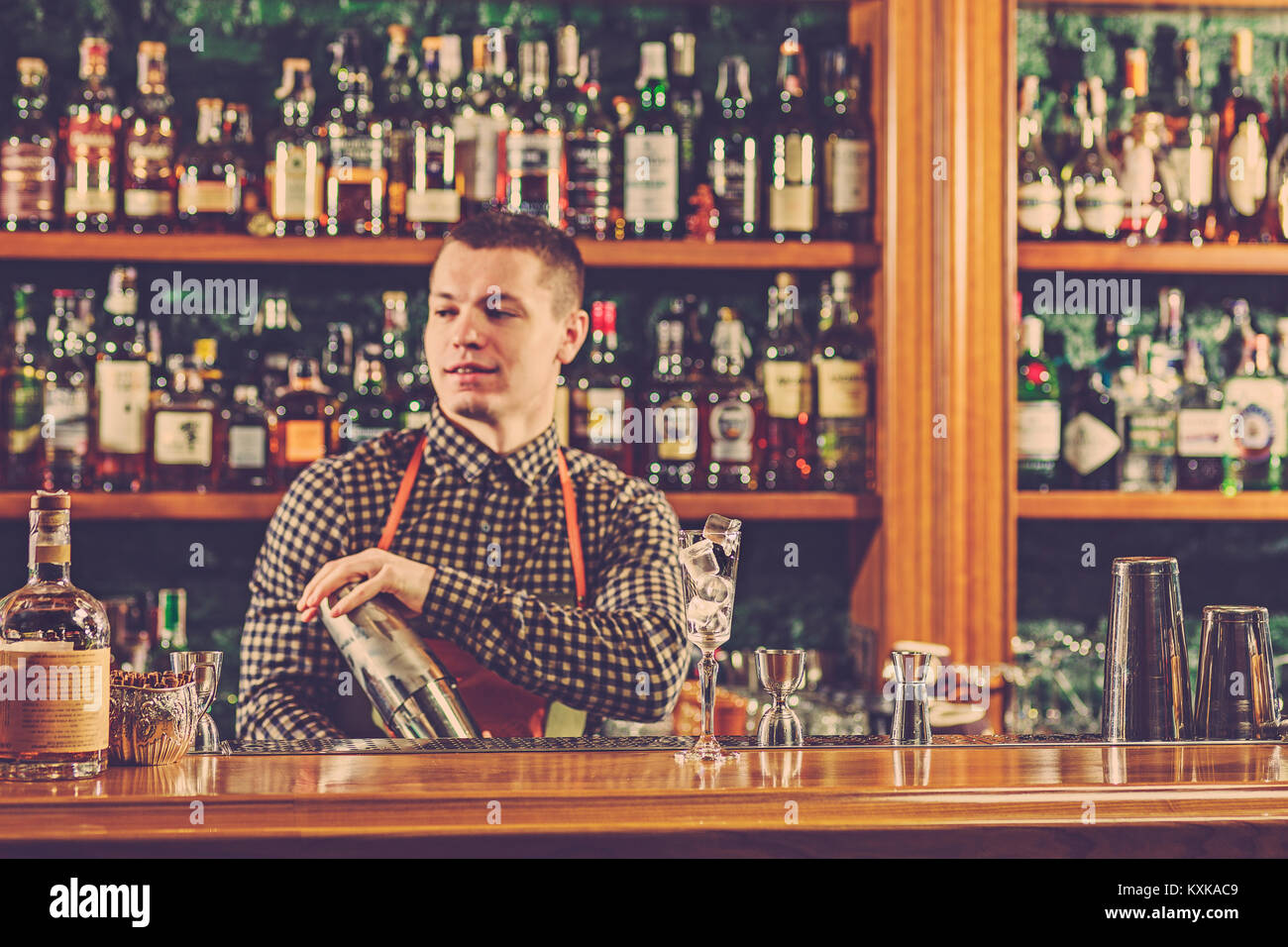 Barman making an alcoholic cocktail at the bar counter on the bar ...
