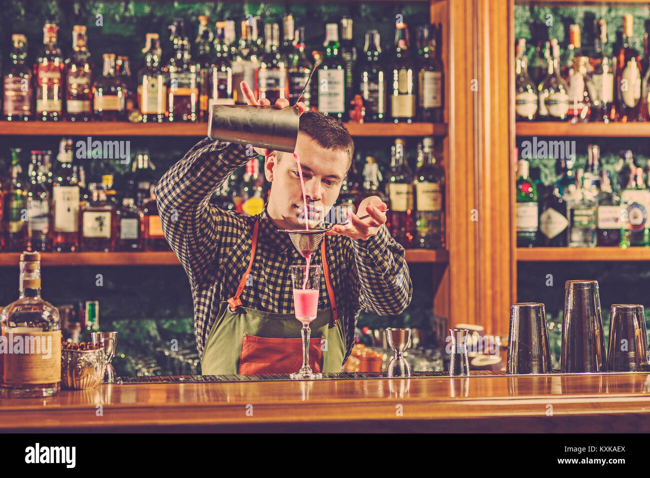 Barman making an alcoholic cocktail at the bar counter on the bar ...