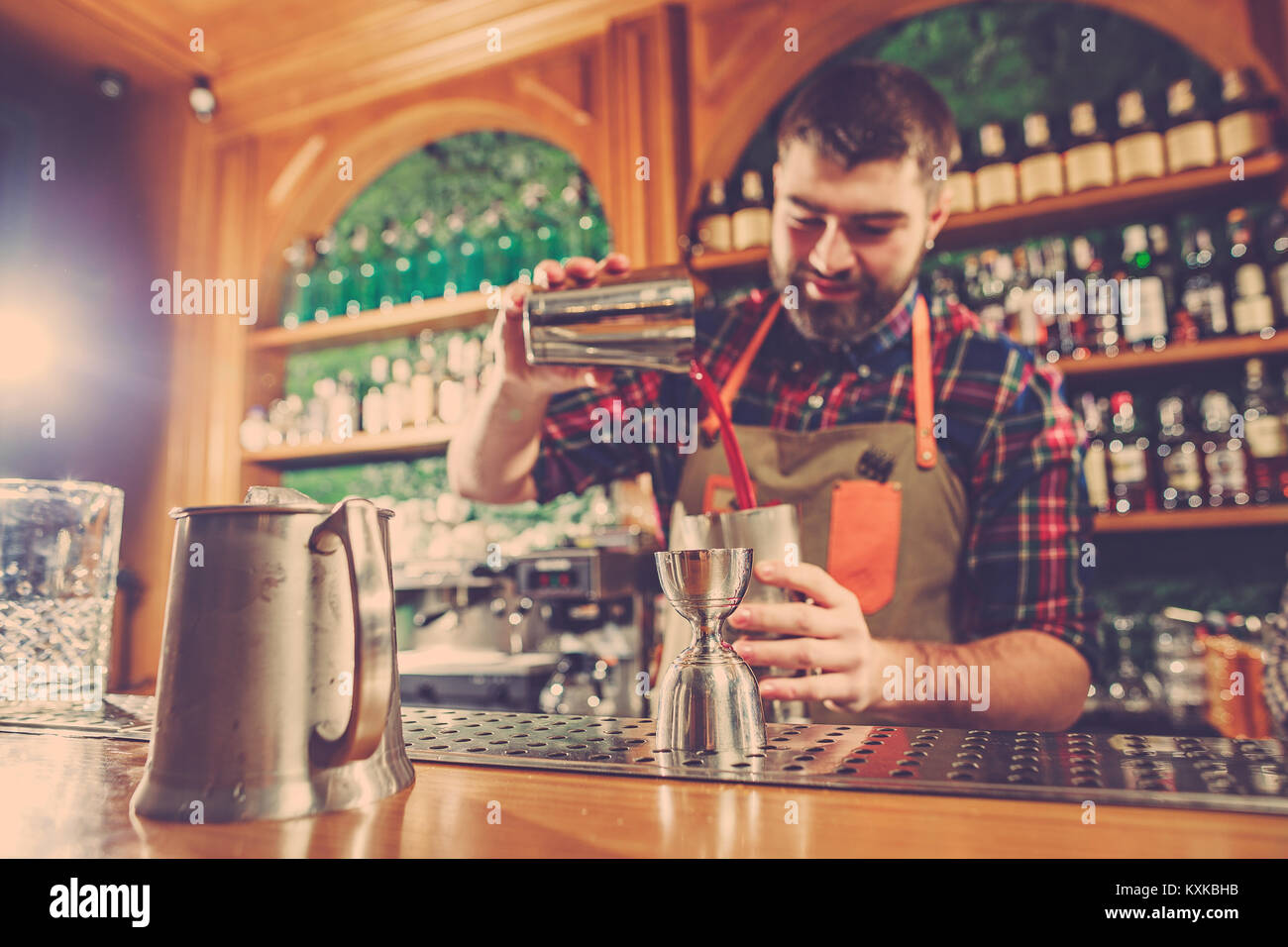 Barman making an alcoholic cocktail at the bar counter on the bar ...