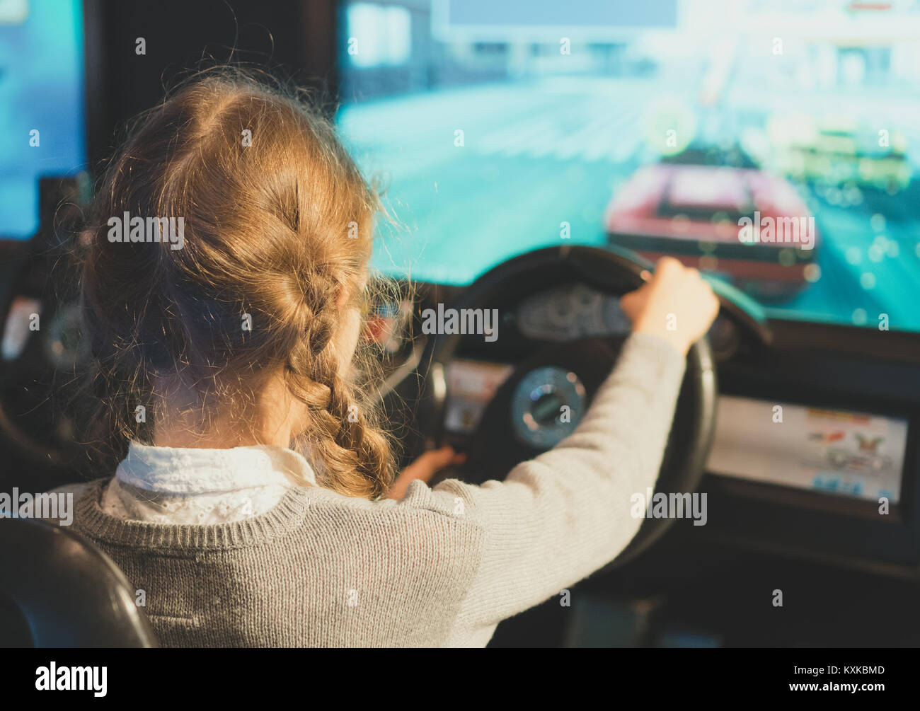 Little girl playing racing simulator game in theme park Stock Photo - Alamy