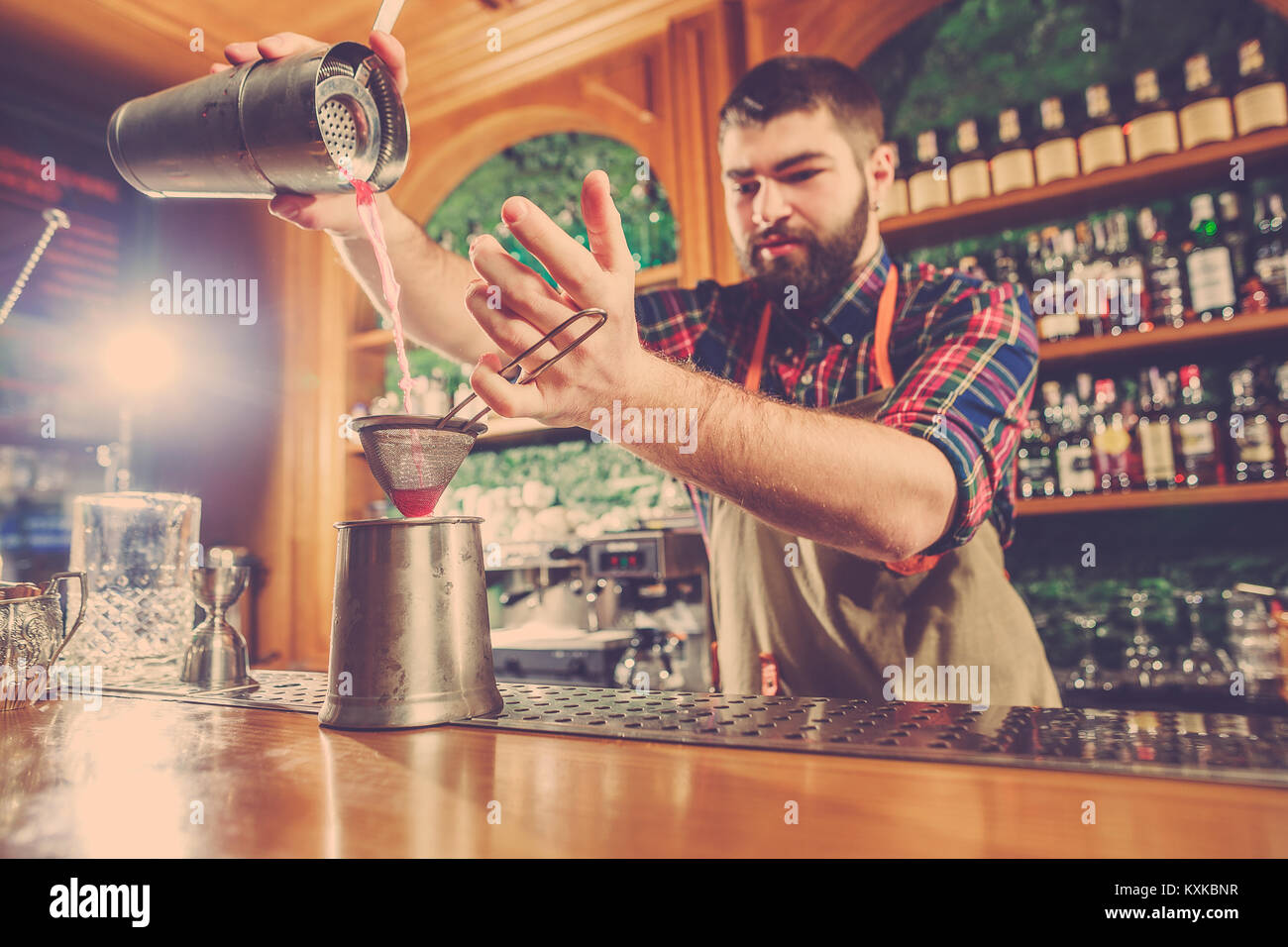 Barman making an alcoholic cocktail at the bar counter on the bar ...