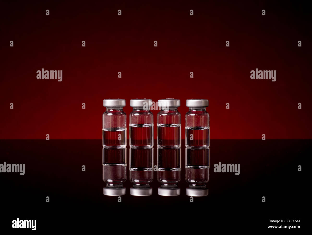 Medical Vials with clear liquid isolated og red black background Stock ...