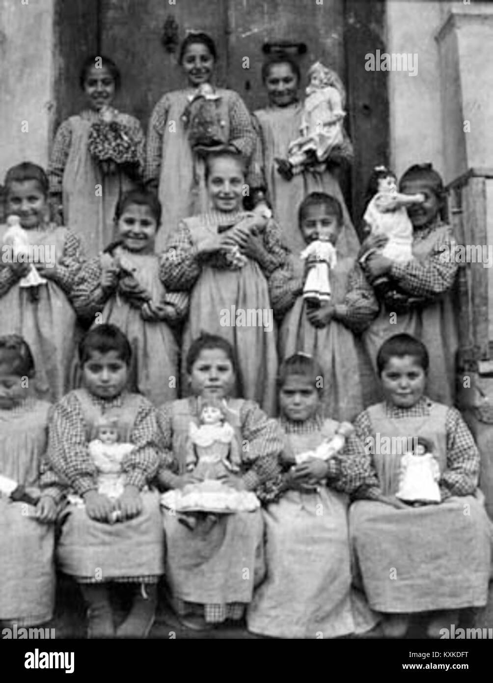 This image features Armenian girls holding dolls. It showcases ...