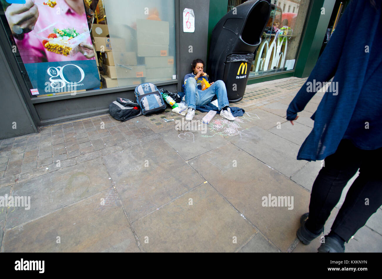 London, England, UK. Homeless man eating on the pavement by a ...