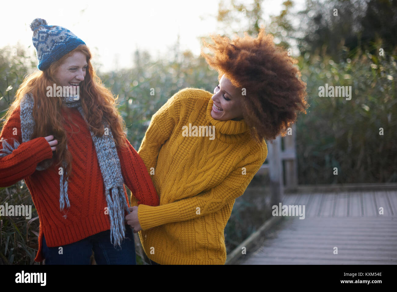 Friends arm in arm laughing Stock Photo - Alamy