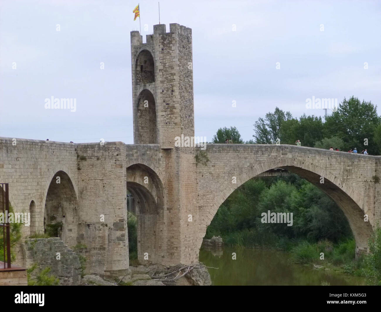 This image shows the Pont Vell in Besal, Spain. The historic bridge ...