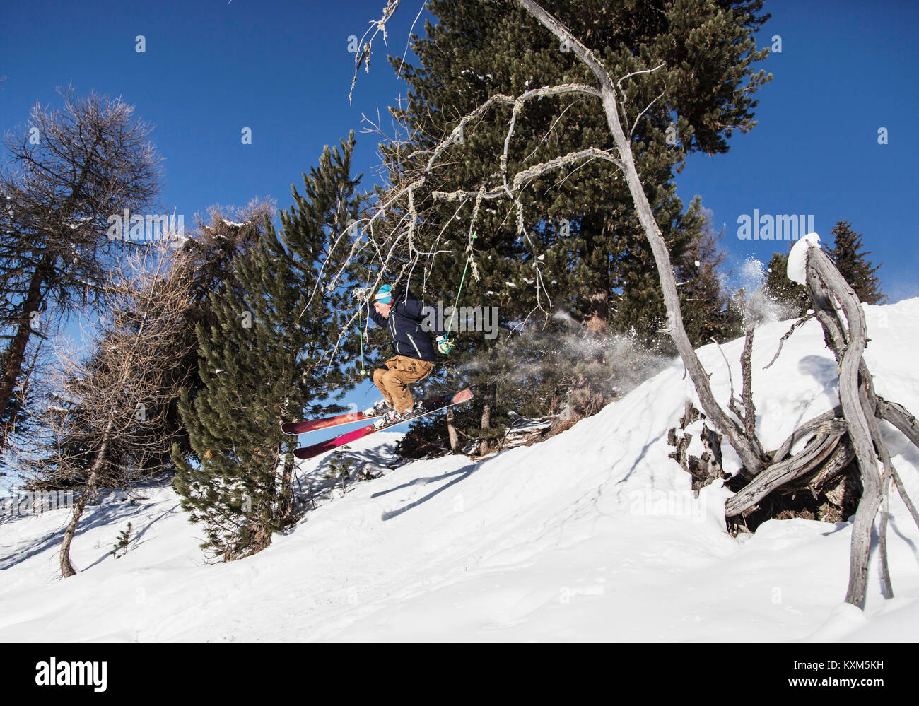 Skier skiing down mountainside,jumping in mid air Stock Photo - Alamy