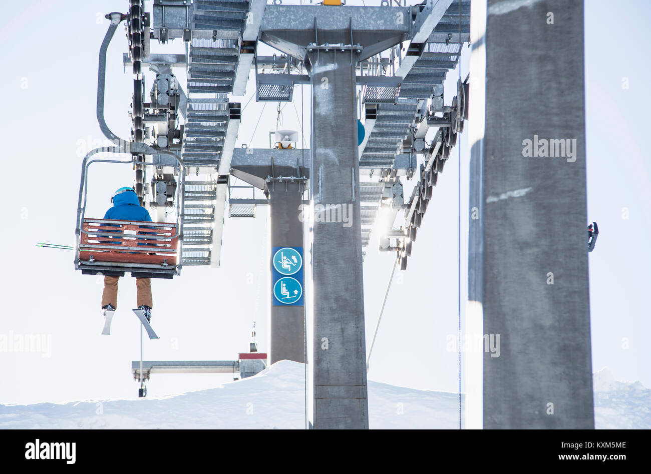 Skier on ski lift,rear view Stock Photo - Alamy