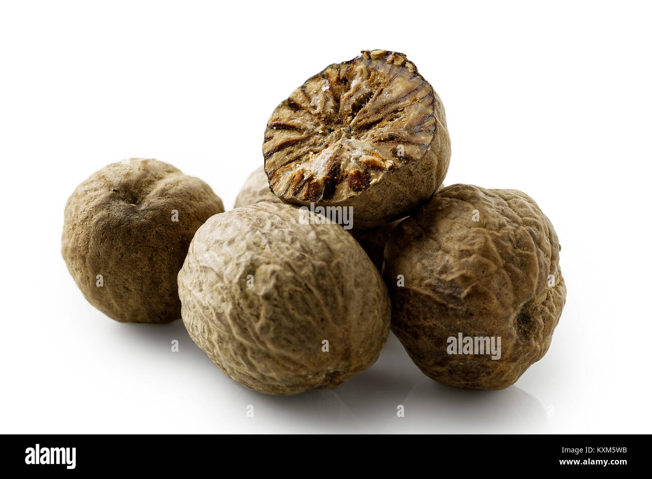 A pile of dried whole nutmegs isolated on white. A cut nutmeg Stock ...