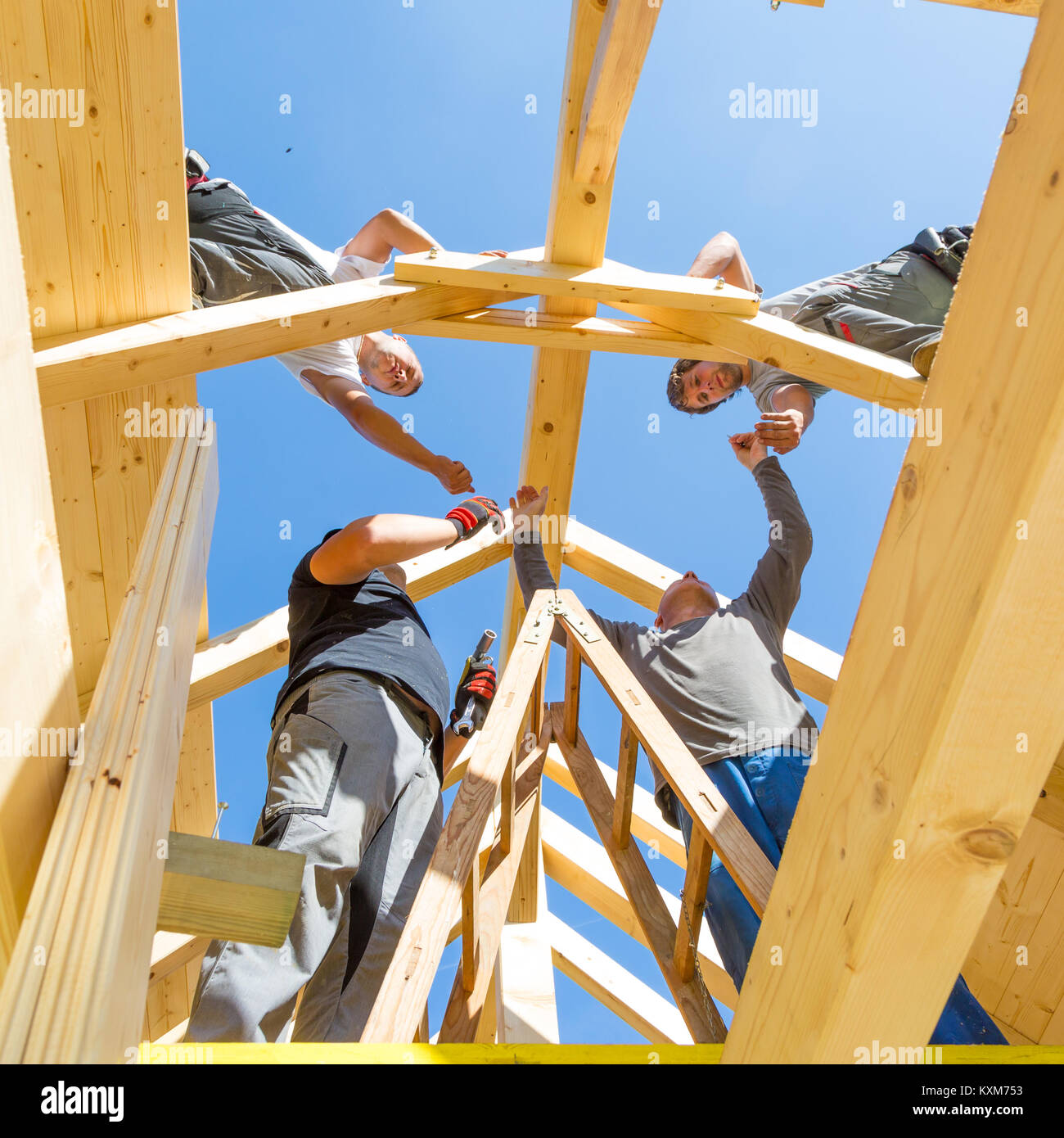 Builders at work with wooden roof construction Stock Photo - Alamy
