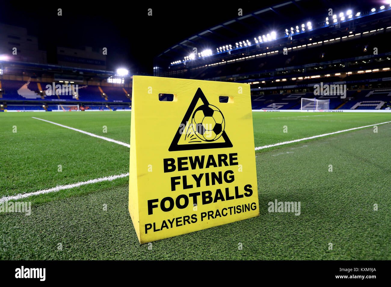 A Beware Flying Footballs sign is put on the pitch whilst the players ...