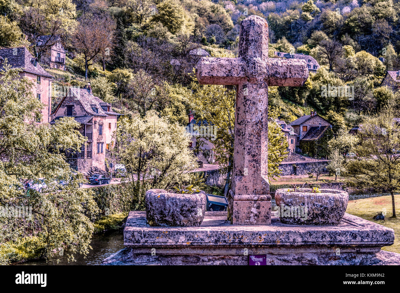 Catholic cross on bridge that crosses the river Aveyron in the medieval ...