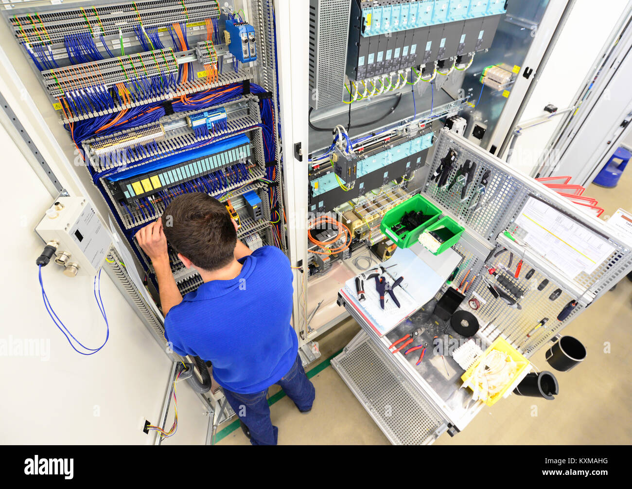 man assembles electronic components on a machine in a factory for ...