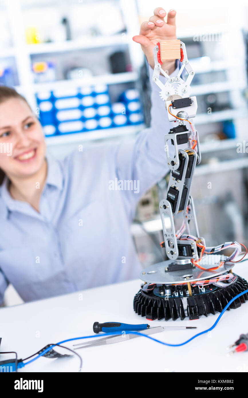 A girl in a University laboratory is experimenting with a robot Stock ...