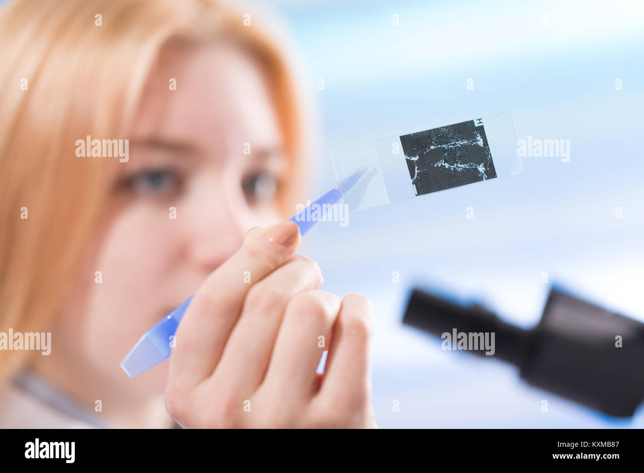 Doctor woman working a microscope. Female scientist looking through a ...