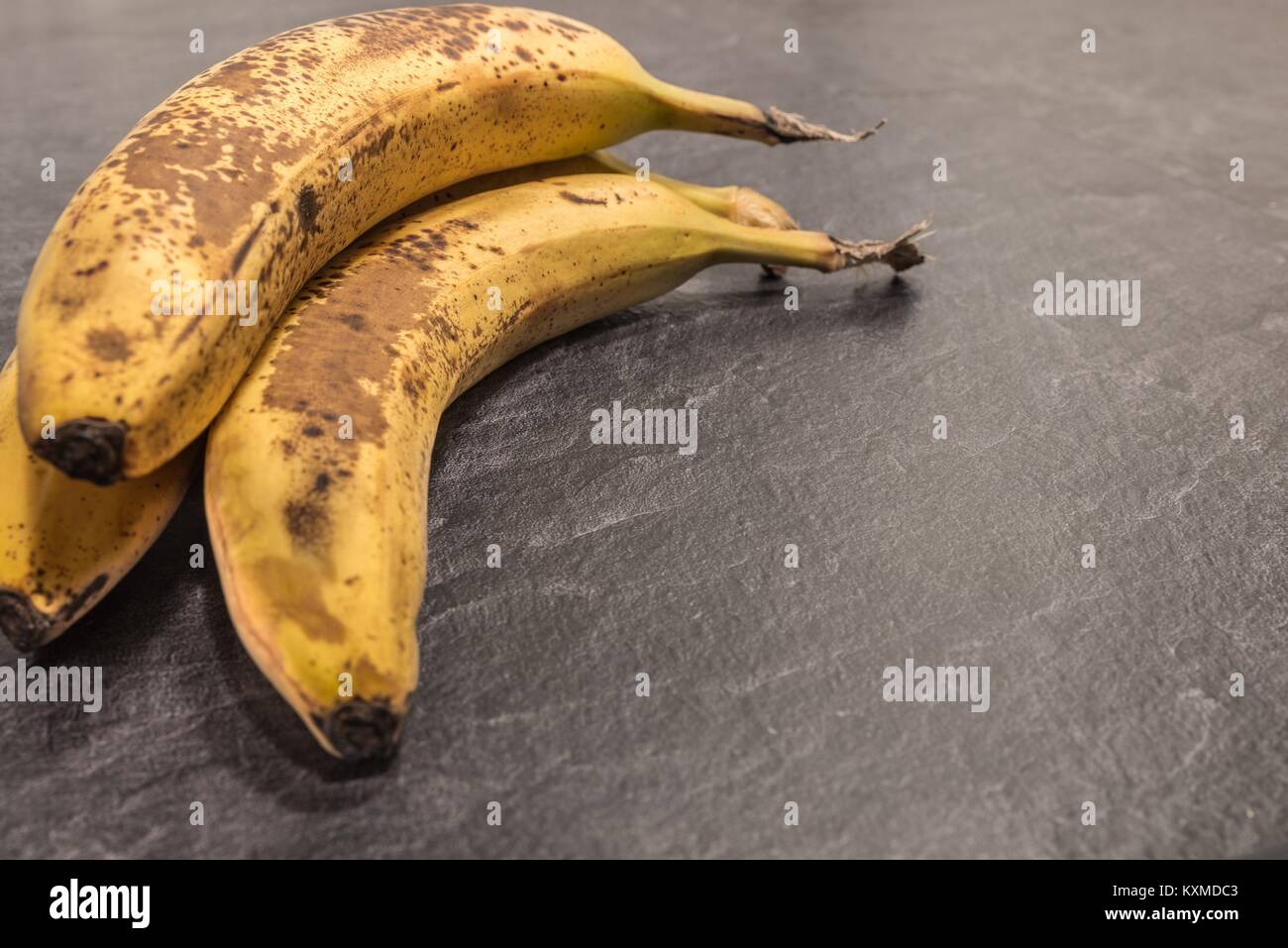 Matured bananas on grey working surface Stock Photo - Alamy