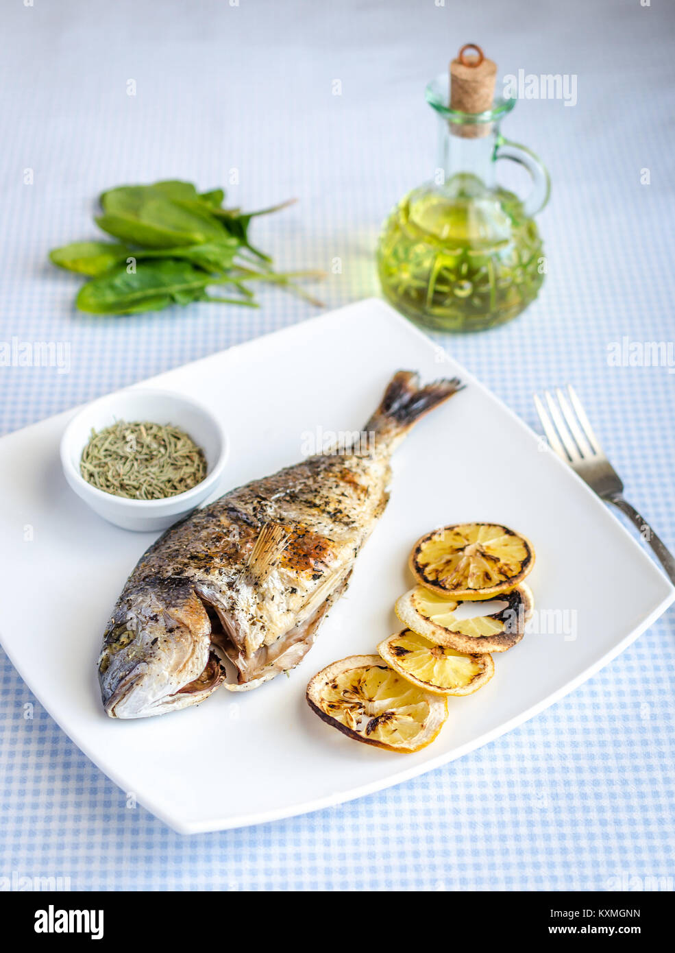 Grilled dorada fish with lemon and spinach Stock Photo - Alamy