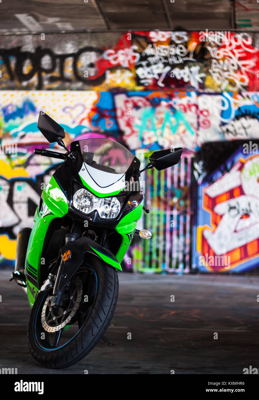 Motorbike under graffitied bridge Stock Photo - Alamy