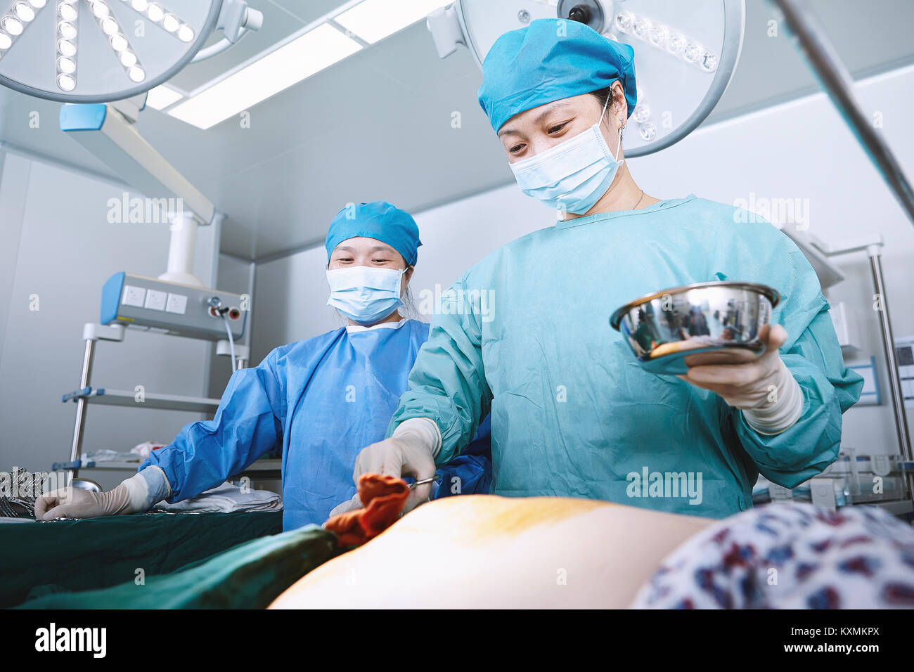 Surgeons swabbing patient abdomen in maternity ward operating theatre ...