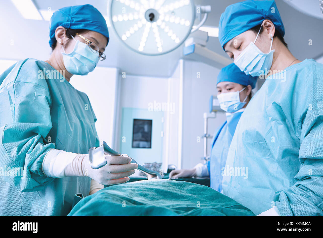 Surgeons performing surgery on patient abdomen in maternity ward ...