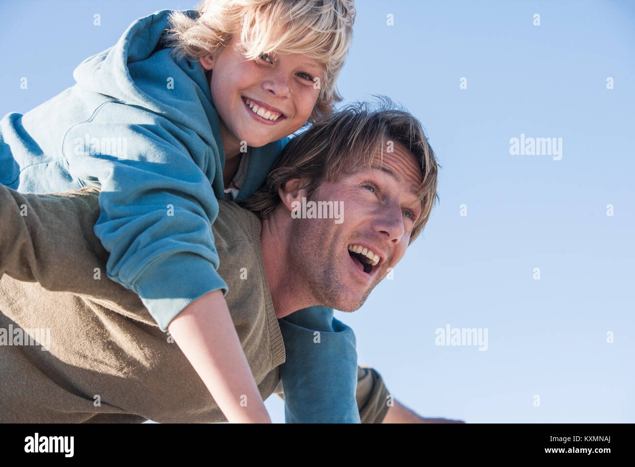 Father carrying smiling boy on back Stock Photo - Alamy