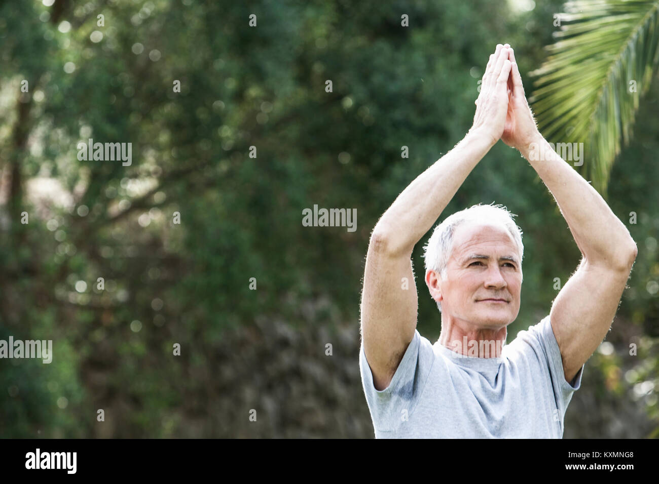 Man,hands together,arms raised in yoga position Stock Photo - Alamy
