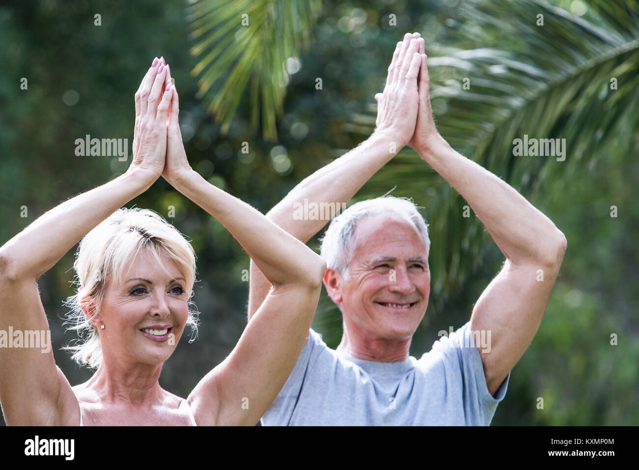 Couple,hands together,arms raised in yoga position Stock Photo - Alamy