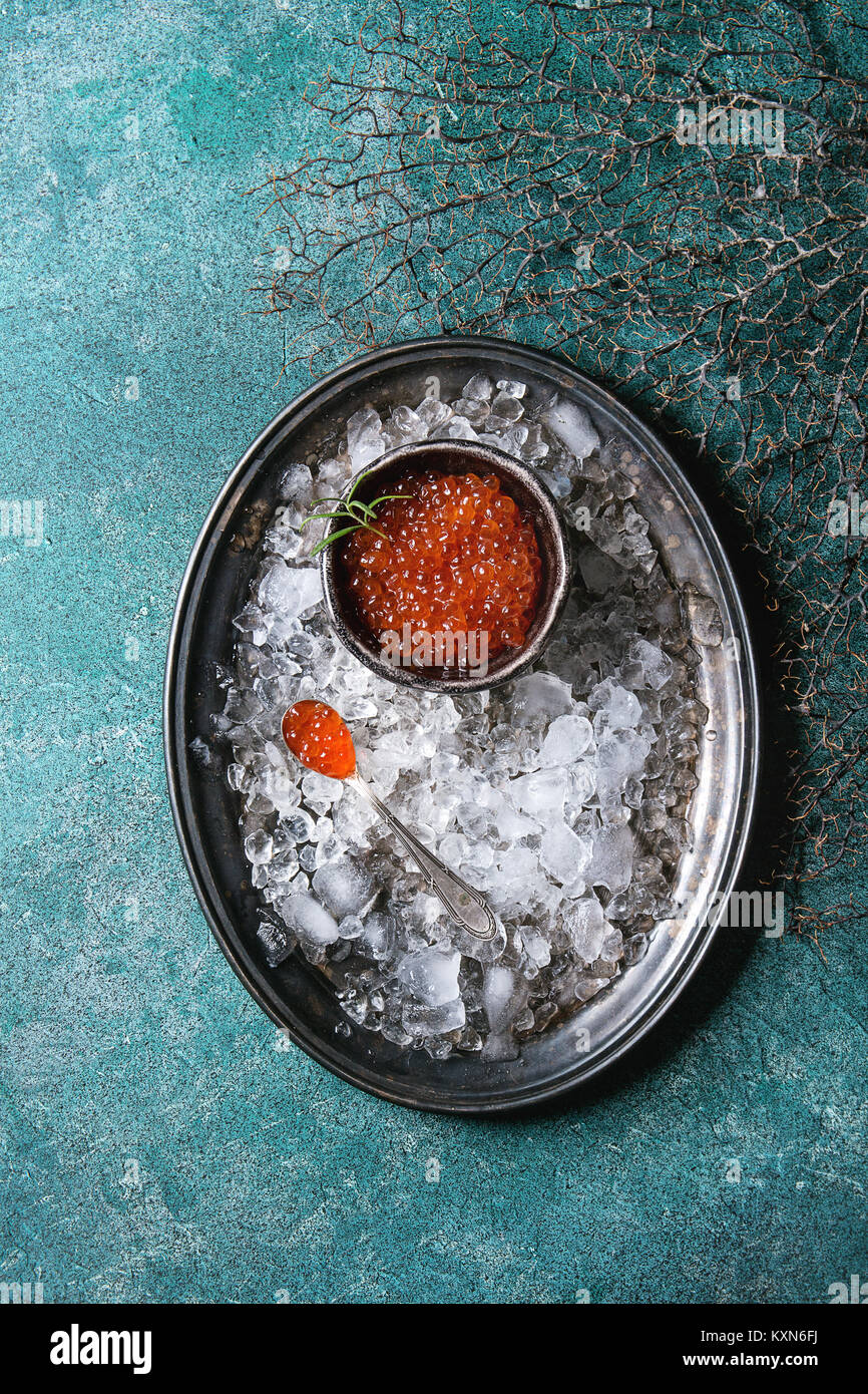 Bowl of red caviar on vintage metal tray with ice over turquoise ...