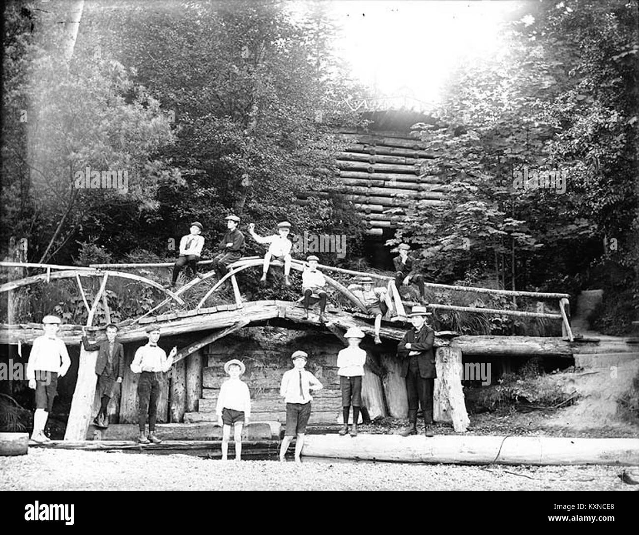 This historical photograph captures boys playing on a bridge in Pt ...