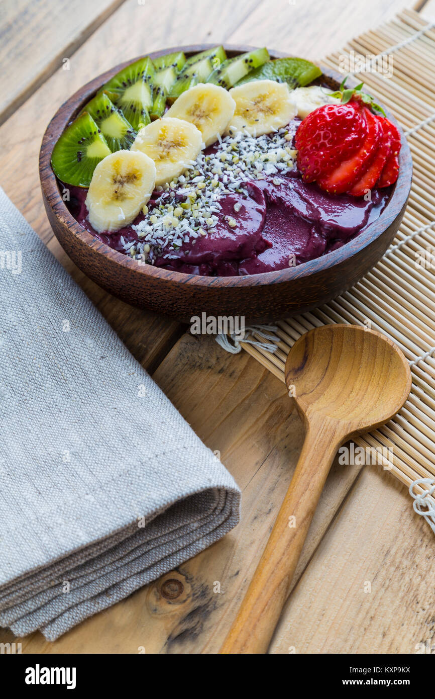 Acai bowl on wooden table - Bowl of acai purée with toppings of banana ...
