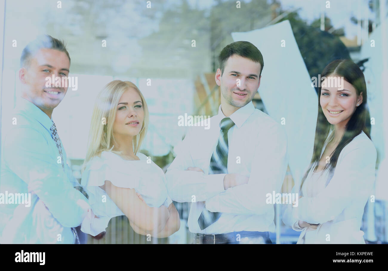 Happy smiling business team looking through window Stock Photo - Alamy