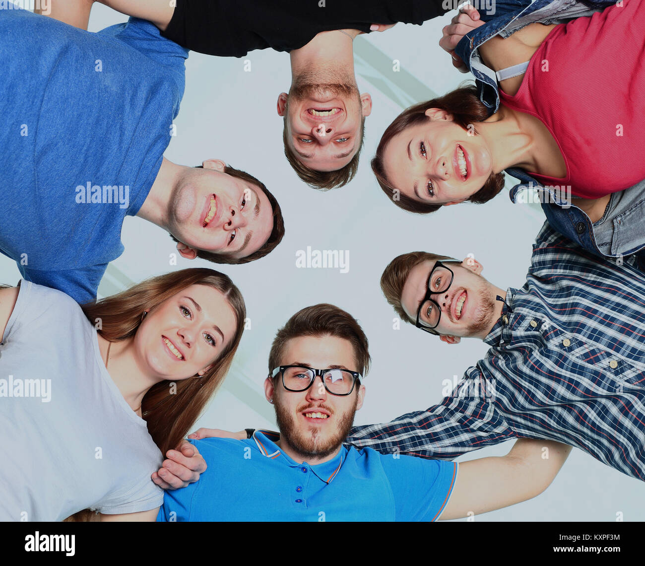 portrait of confident college students forming huddle over white ...