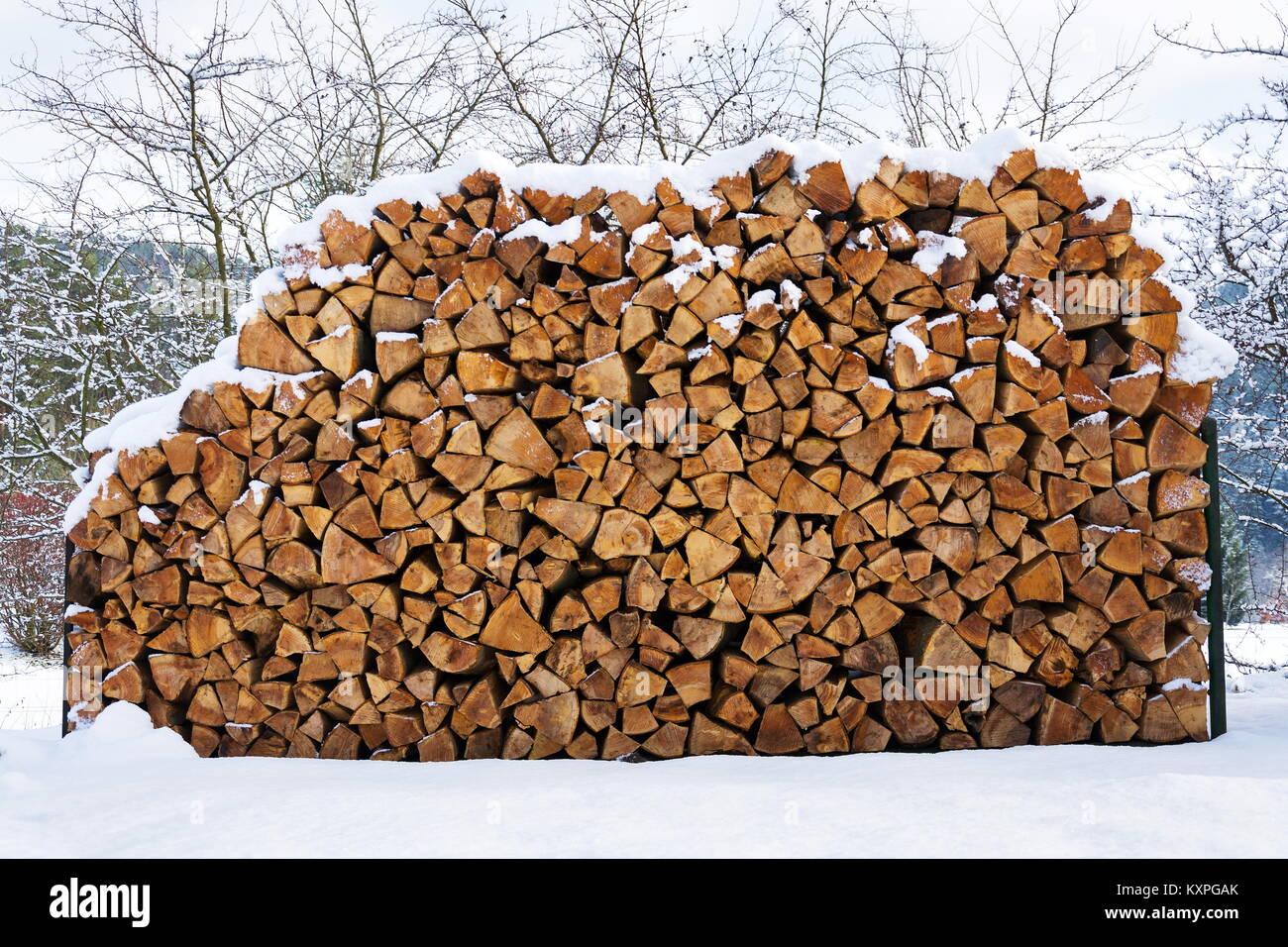 Beautiful stack of chopped firewood in snowy country, sunny winter ...