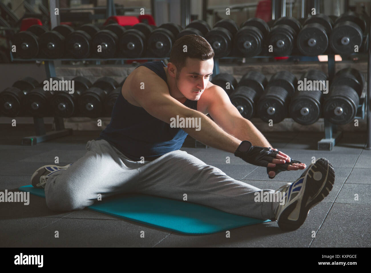 Young handsome man is stretching in the gym Stock Photo - Alamy