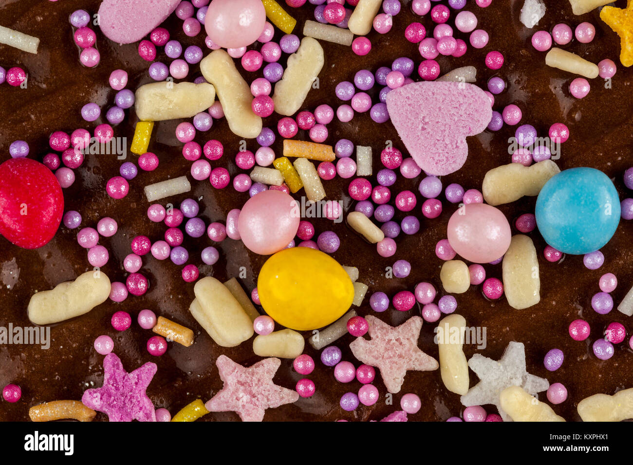 Close up of lots of colourful candy treats sprinkled on the surface of ...