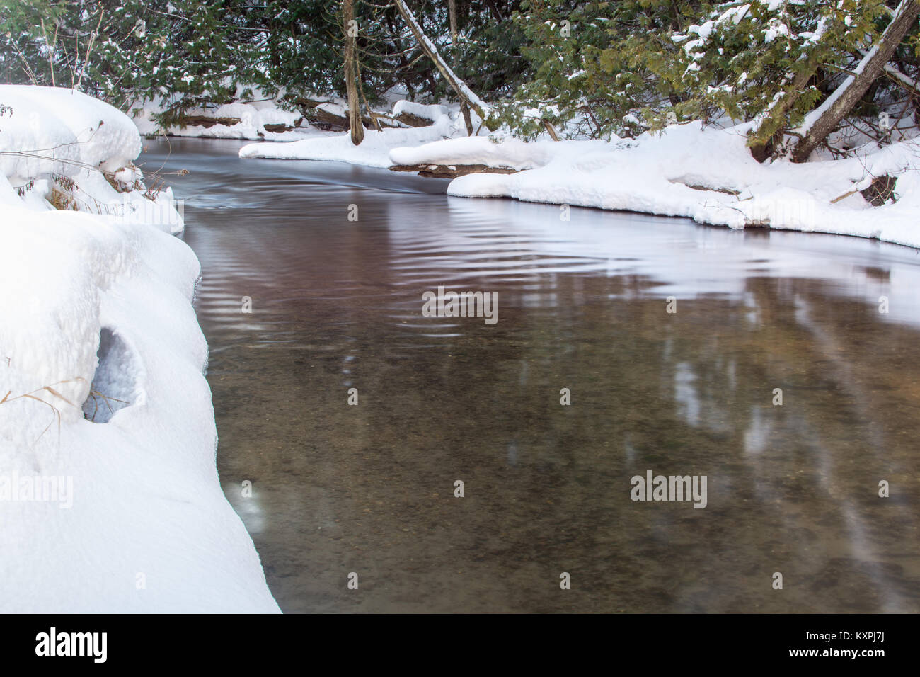 Snow And Ice Covered Creek In Winter Stock Photo - Alamy