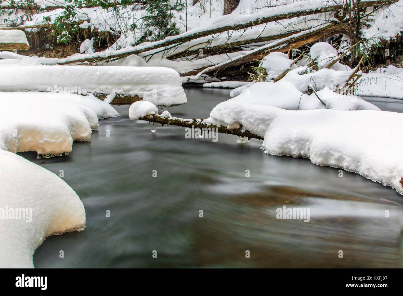Snow And Ice Covered Creek In Winter Stock Photo - Alamy