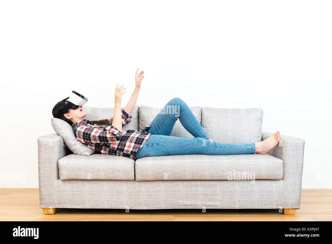 pretty beautiful girl wearing virtual reality goggles device lying down ...