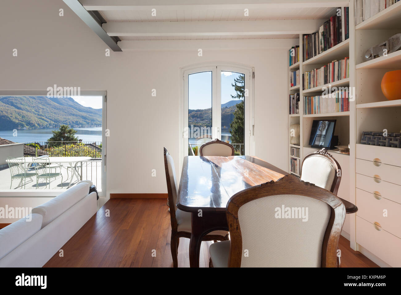 Interiors, dining room of a loft, wooden table and classic style chairs ...