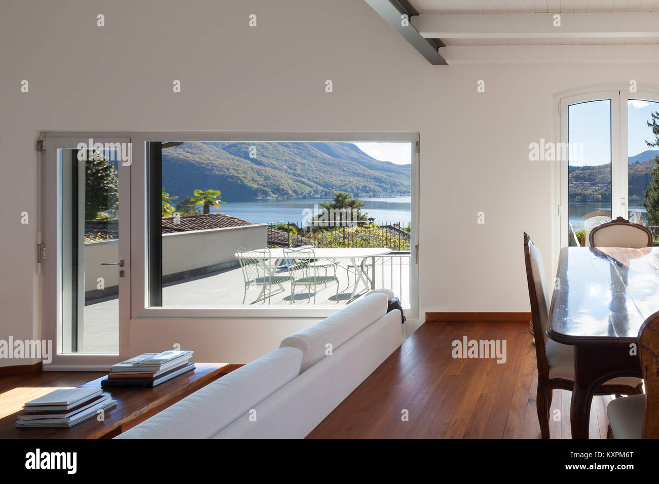 Interiors, living room of a loft, wooden table and white divan Stock ...